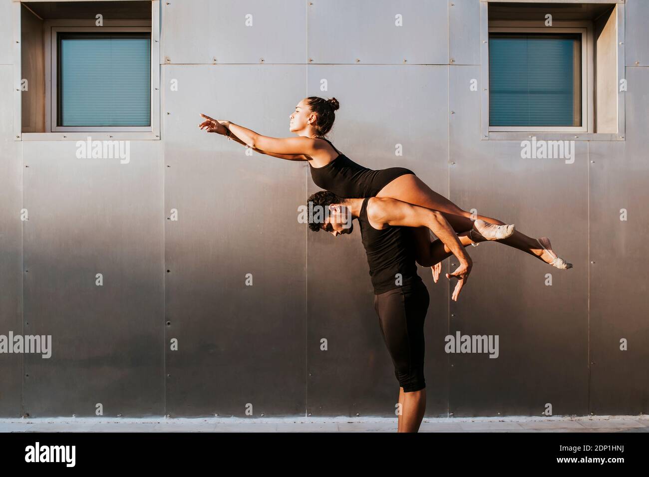 Male gymnast carrying female on shoulders while practicing dance ...