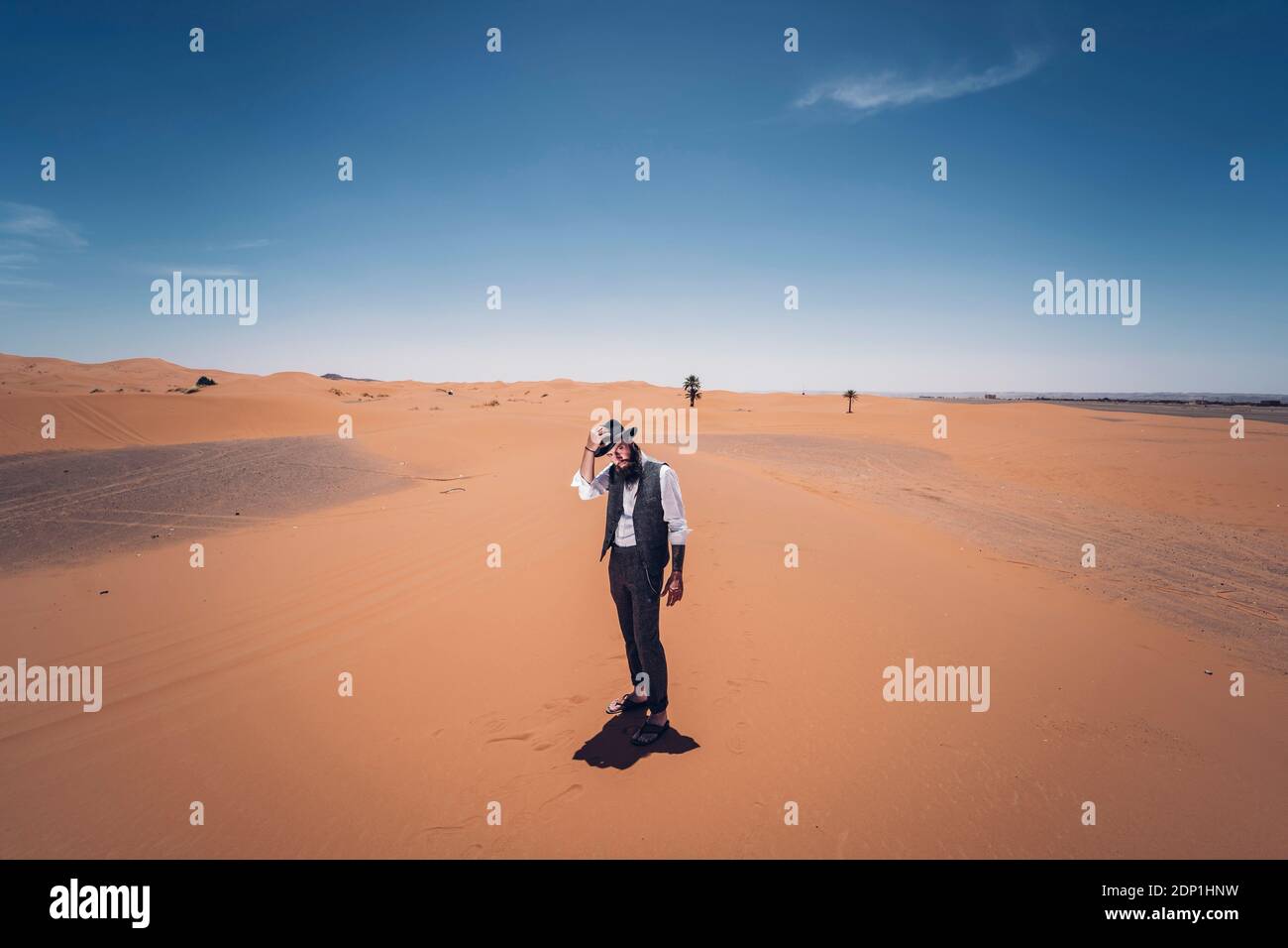 Man with a beard and hat in the dunes of the desert of Morocco Stock ...