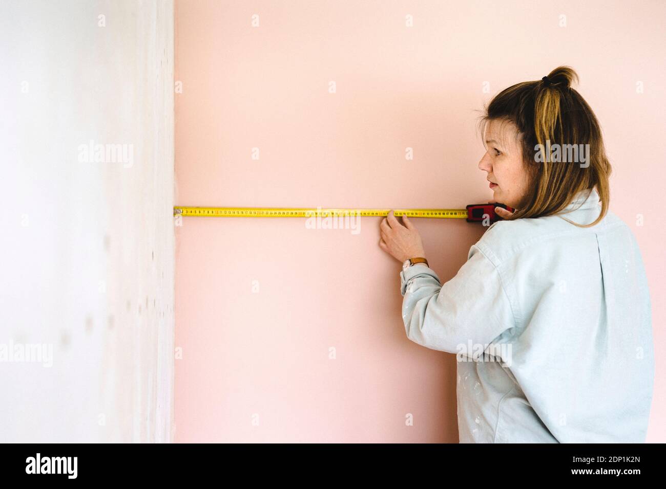Woman measuring wall Stock Photo - Alamy