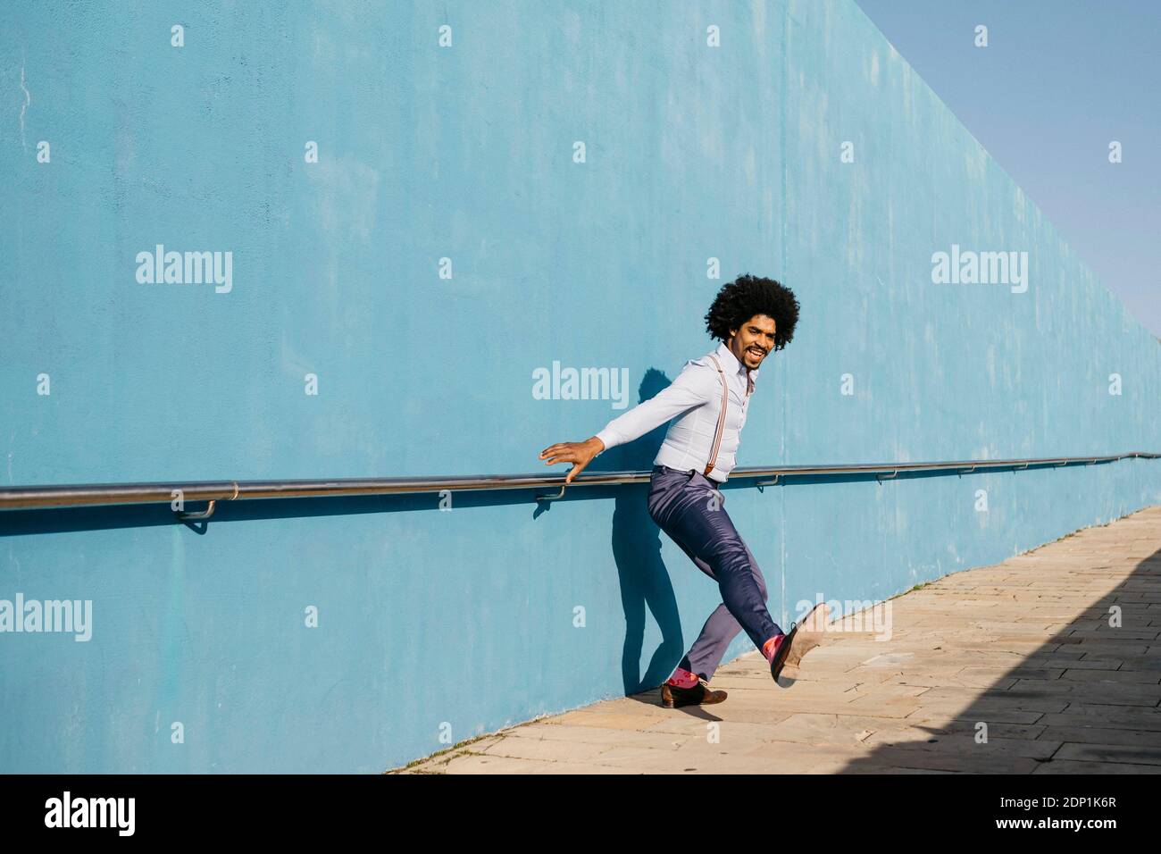 Man dancing in front of blue wall Stock Photo - Alamy