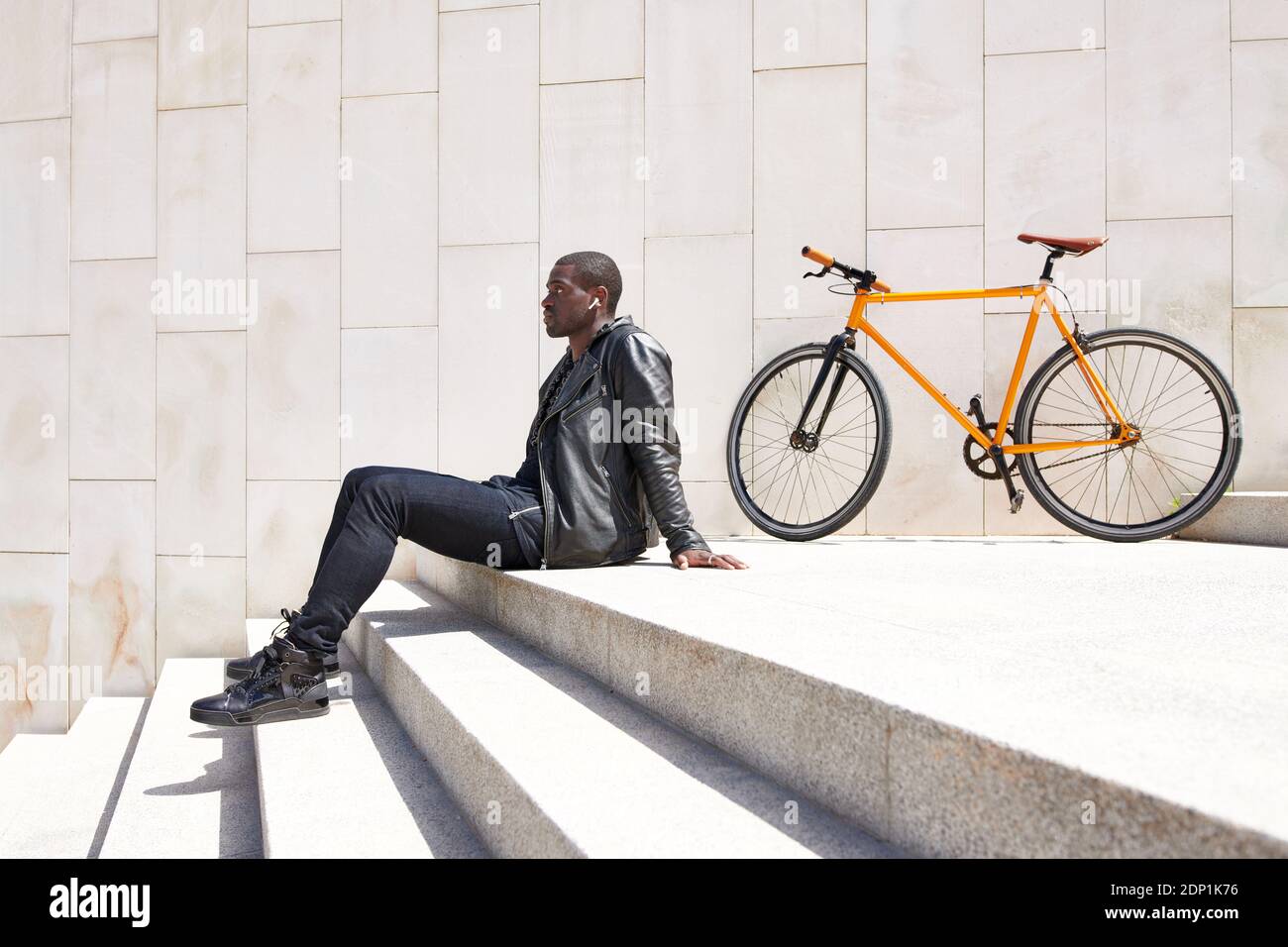 Man sitting on step next to his bike Stock Photo - Alamy