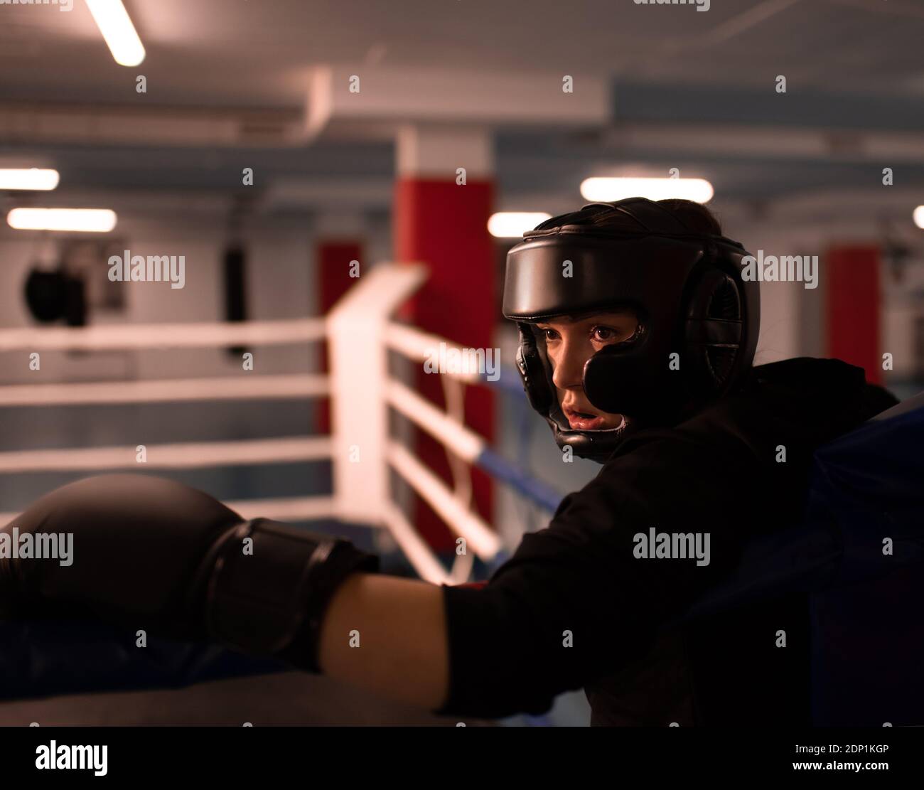 Back view of concentrated strong woman in protective gear looking away ...