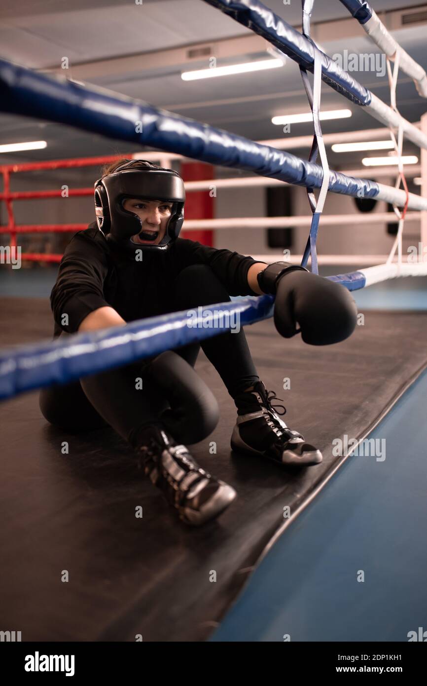 Full body aggressive female boxer in protective gear screaming while ...