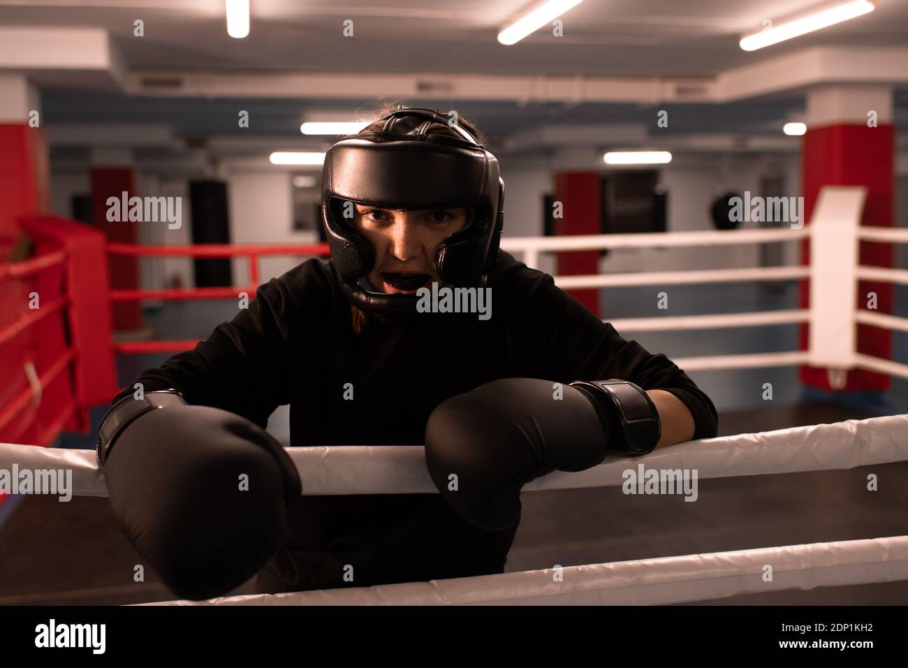 Positive powerful woman in protective helmet and gloves looking at ...