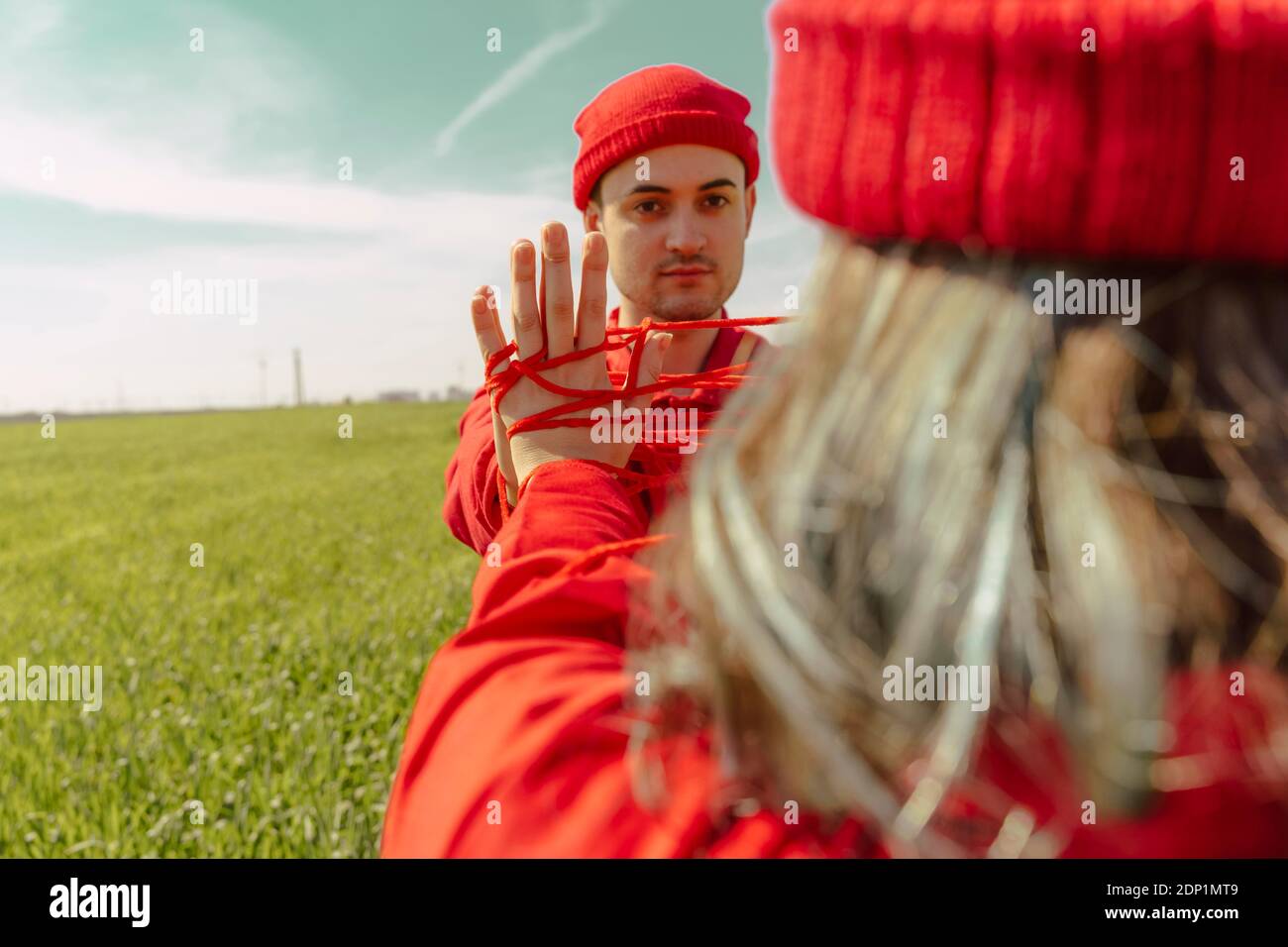 Portrait of young man dressed in red performing with his girlfriend on ...