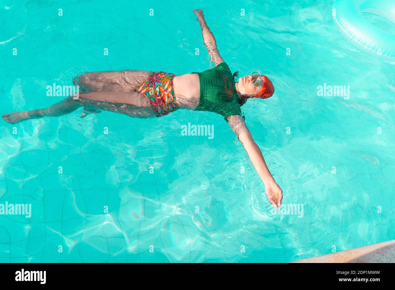 Woman floating on water in swimming pool Stock Photo - Alamy