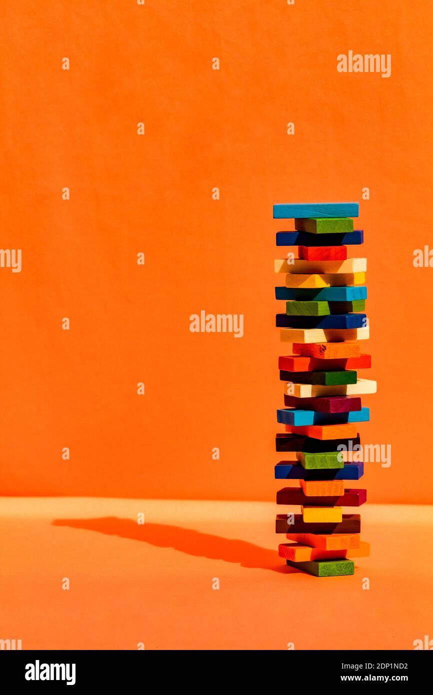 Tower of colorful construction blocks against orange background Stock ...
