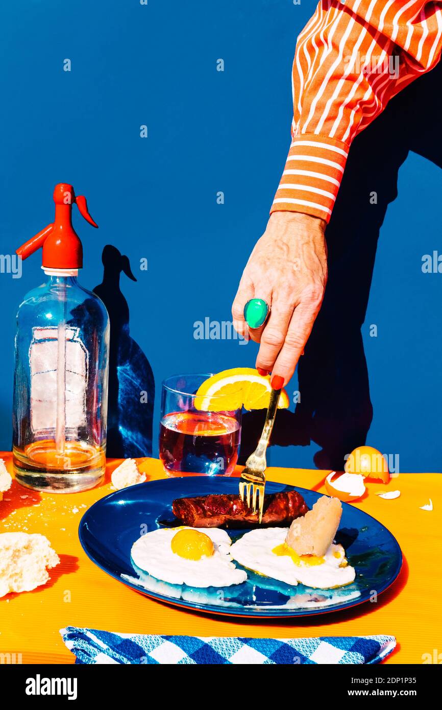 Arm of woman eating fried eggs with chorizo Stock Photo - Alamy