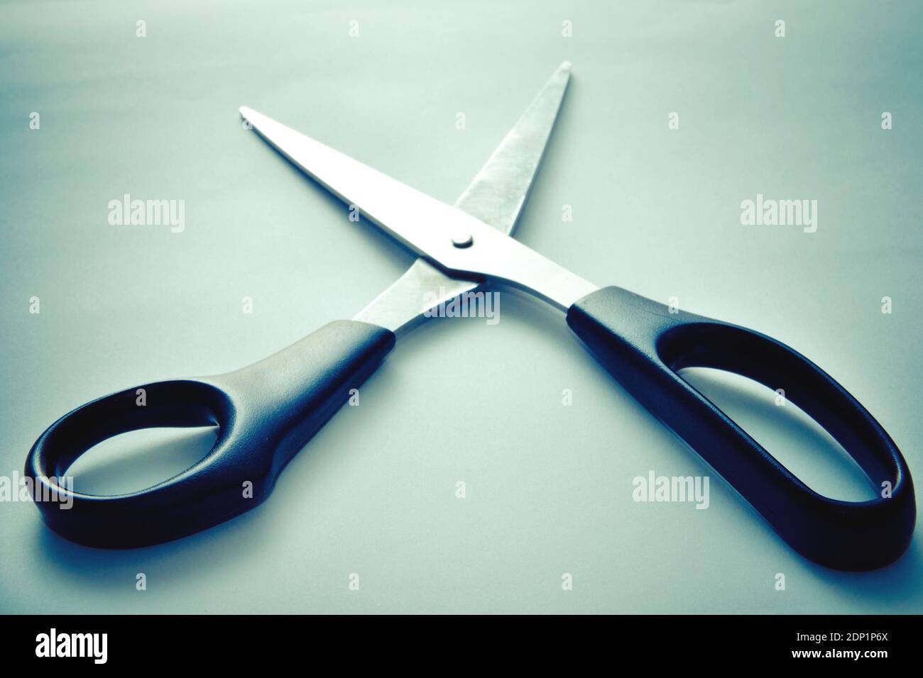 open scissors on the green background Stock Photo - Alamy