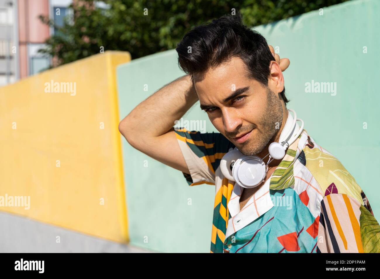 Dark haired man standing front colorful wall hi-res stock photography ...