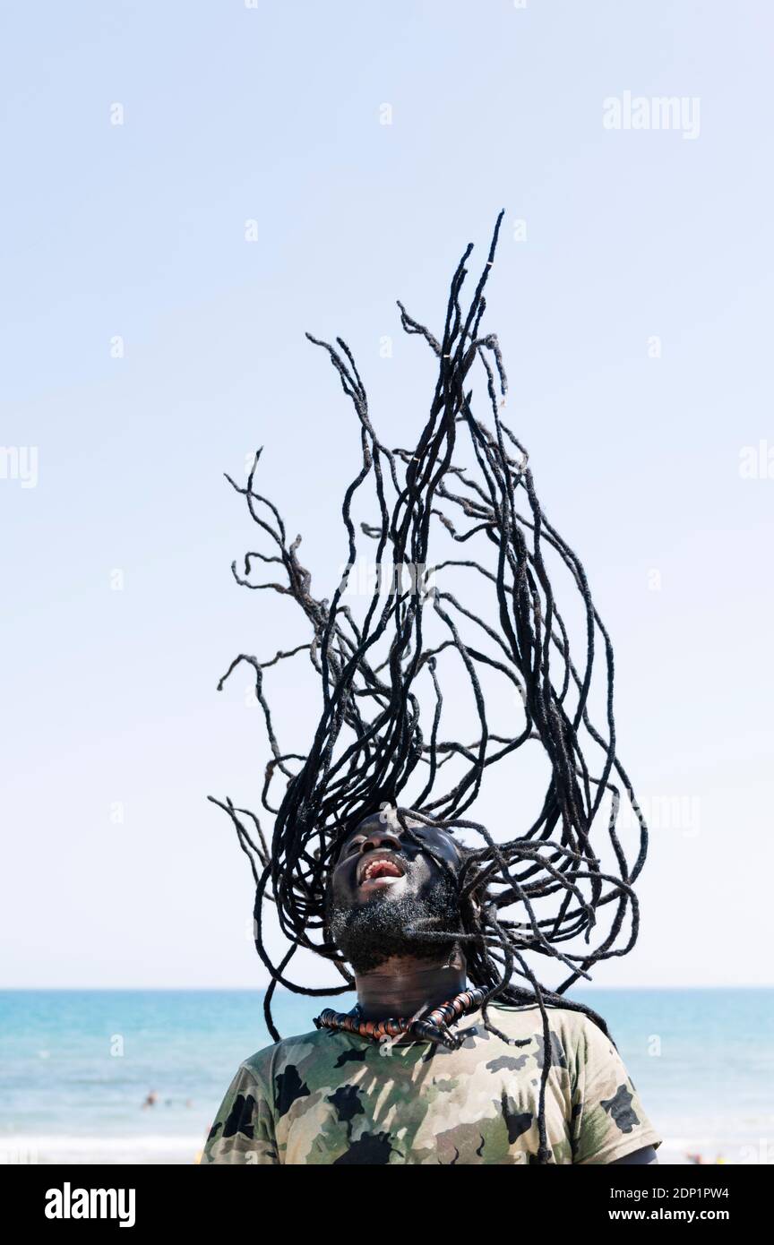 Rastafari man tossing his dreadlocks on the beach Stock Photo - Alamy