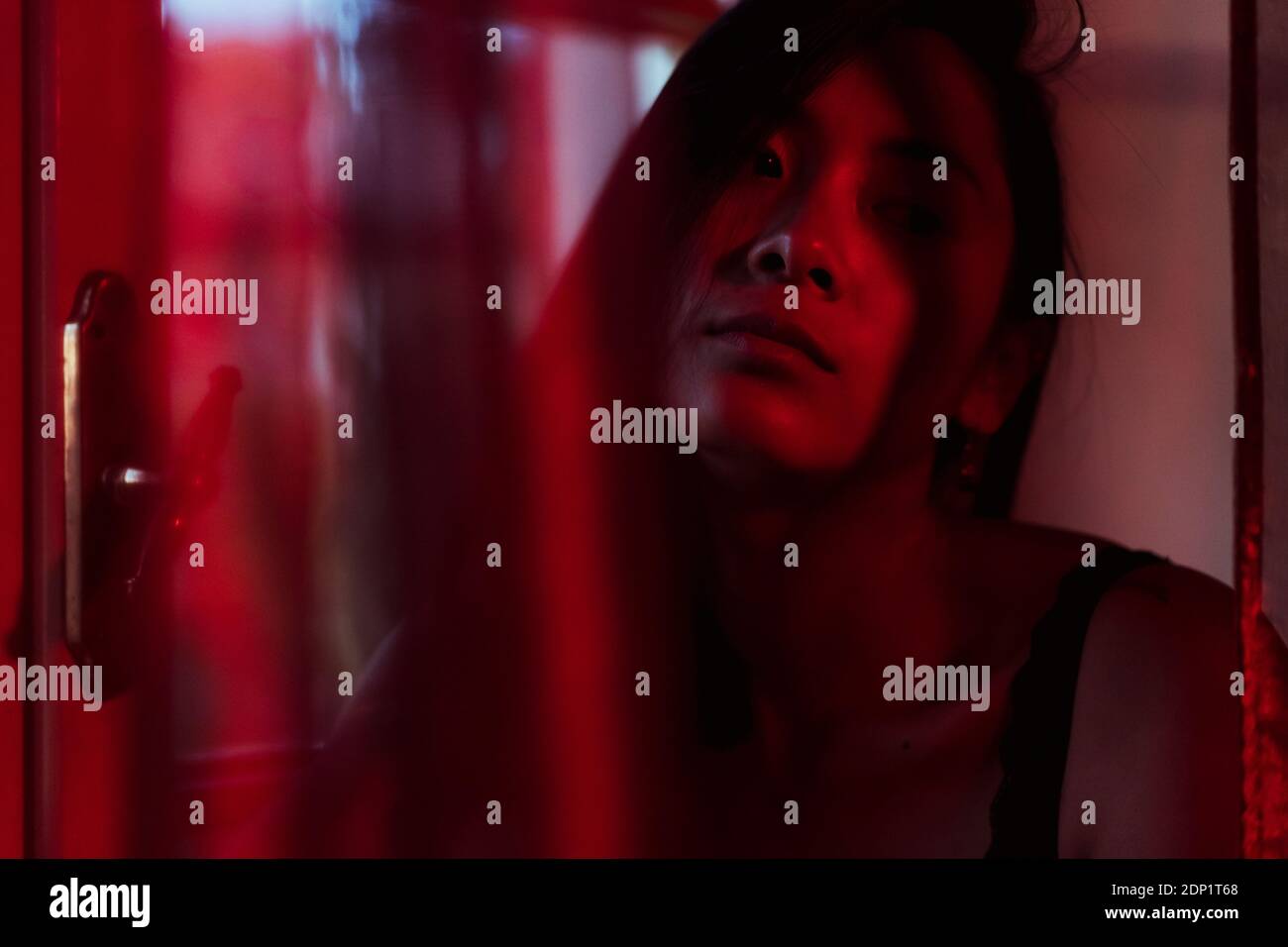Sad woman looking through window at home Stock Photo - Alamy