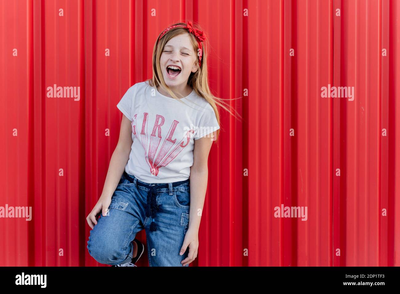Girl screaming in front of red wall Stock Photo - Alamy
