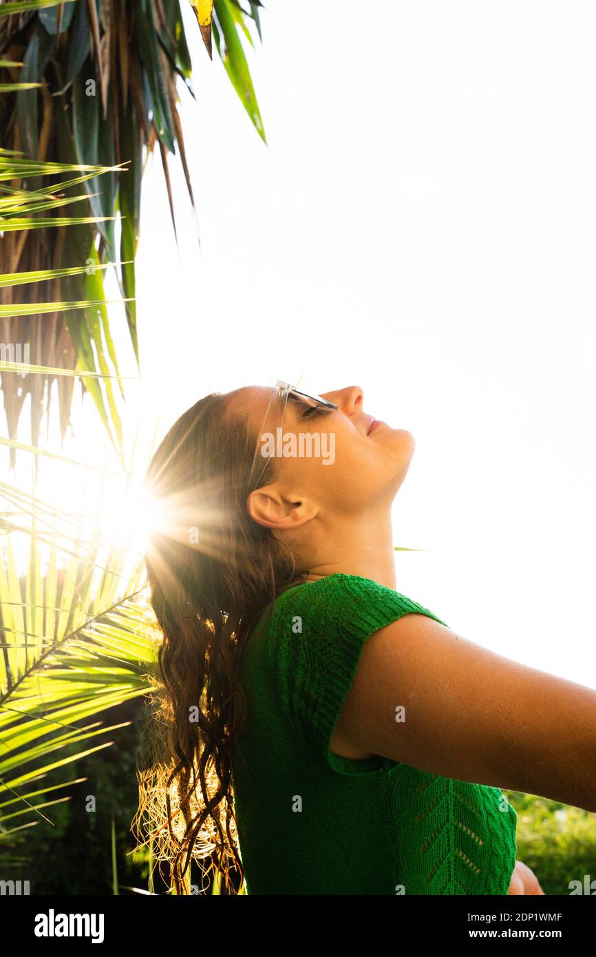Woman under palm trees enjoying gthe sun Stock Photo - Alamy