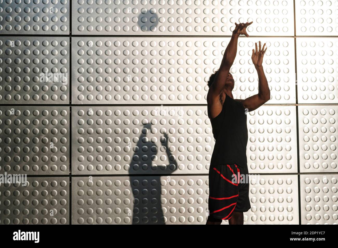Young man playing basketball at a metallic shining wall Stock Photo - Alamy