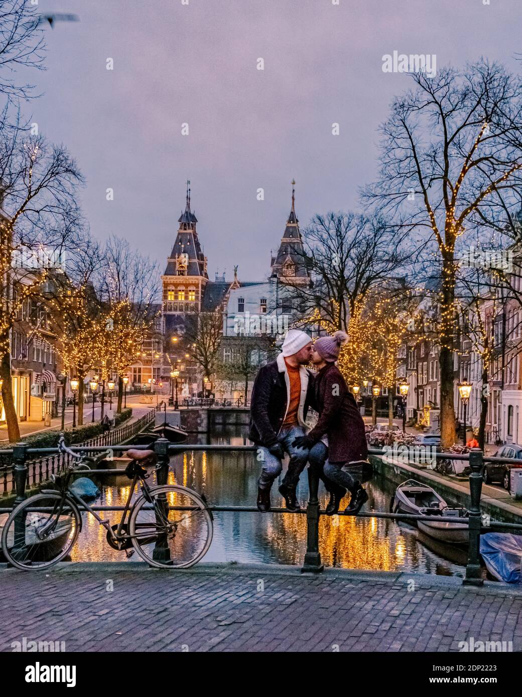 couple on city trip Amsterdam Netherlands canals with Christmas lights ...