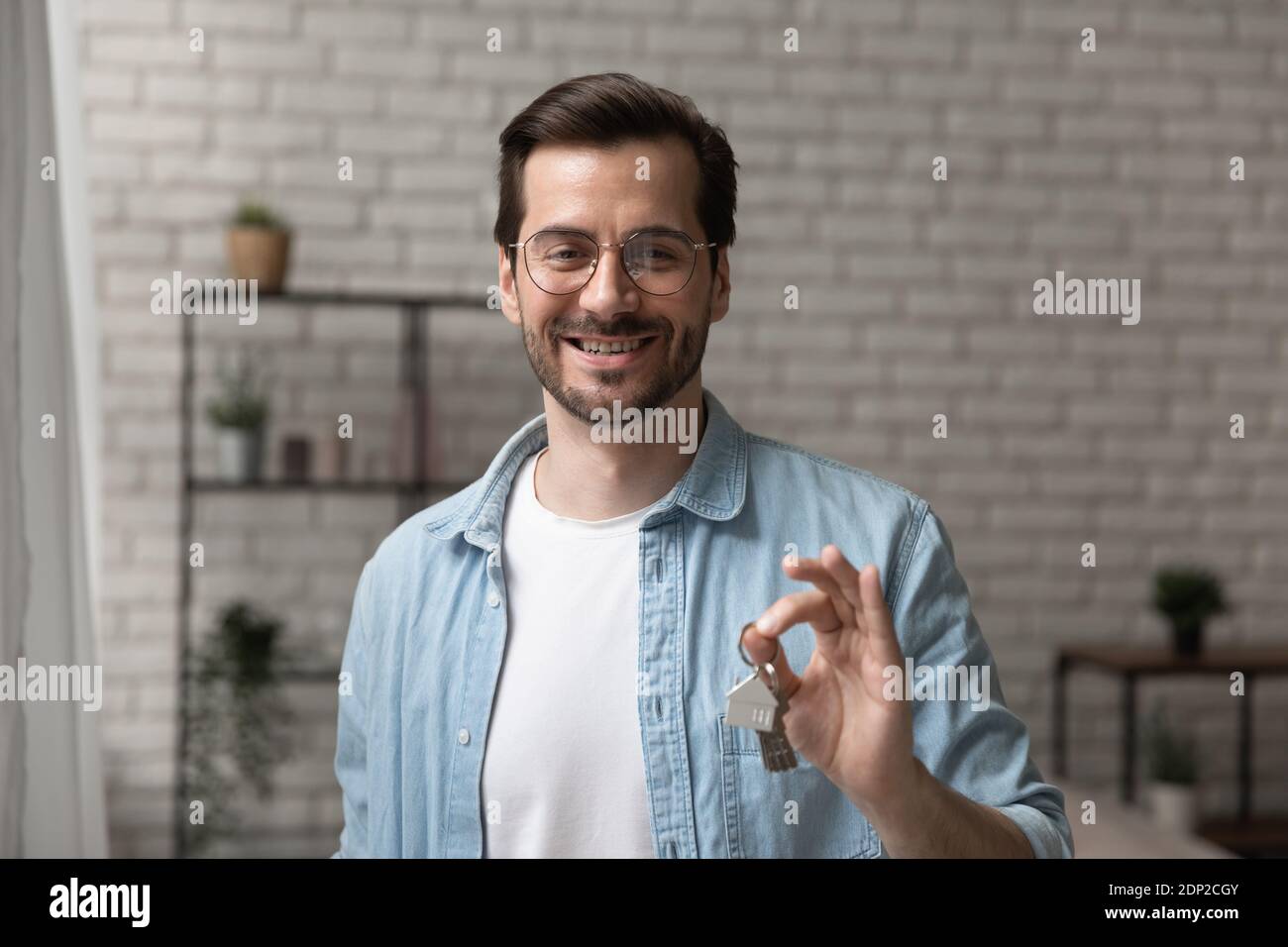 Friendly man broker posing with keys of flat for sale Stock Photo - Alamy