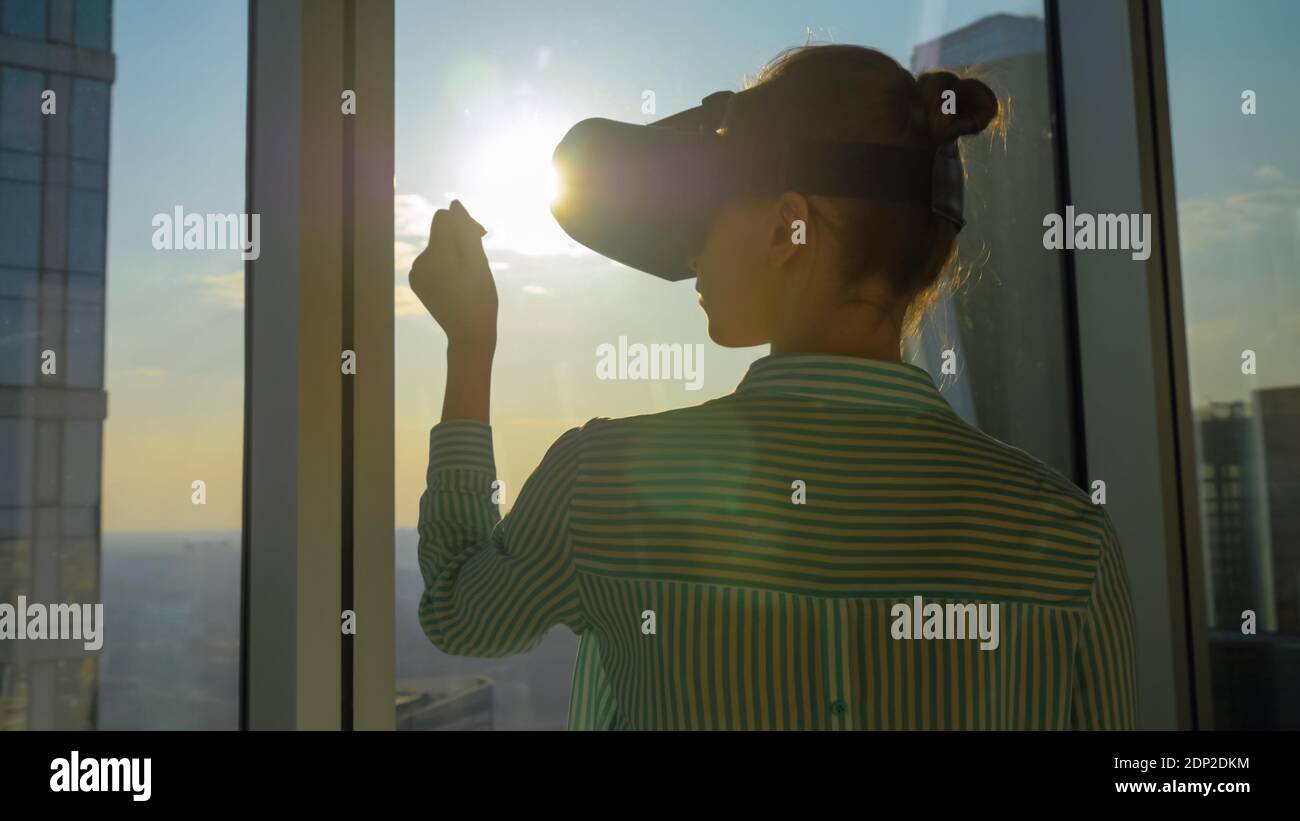 VR concept - young woman using virtual reality headset against ...