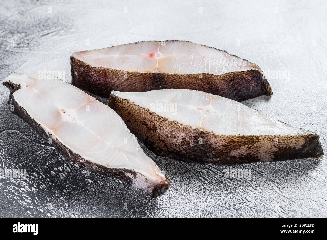 Raw fresh steak fish halibut on the stone table. White background. Top ...