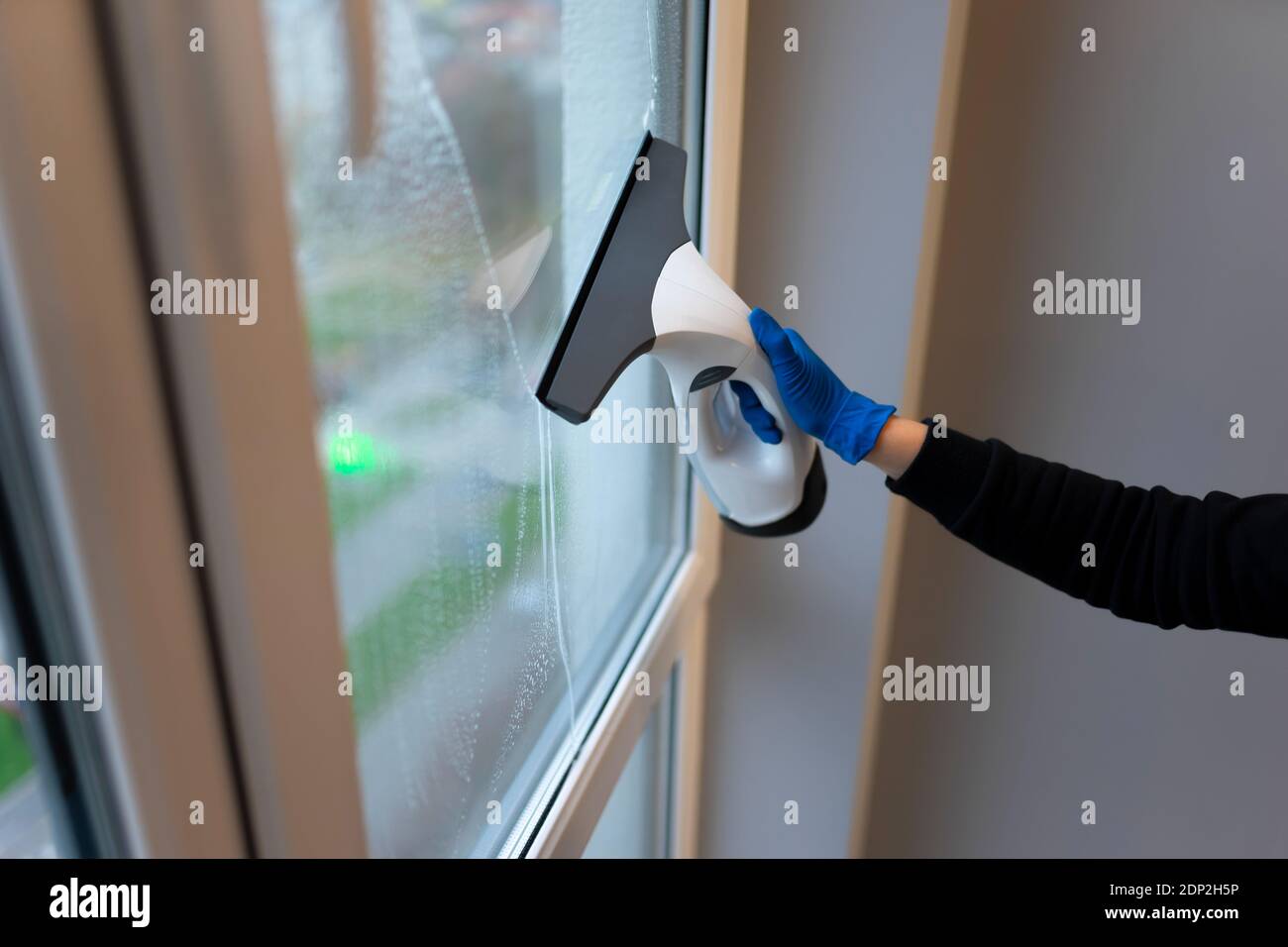 Window cleaning with electric vacuum cleaner. Clean windows concept ...