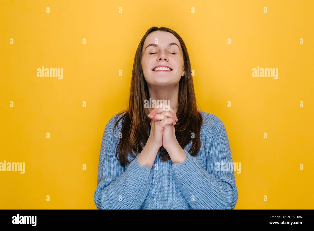 Hopeful young woman clenching fists making wish praying asking dreams ...