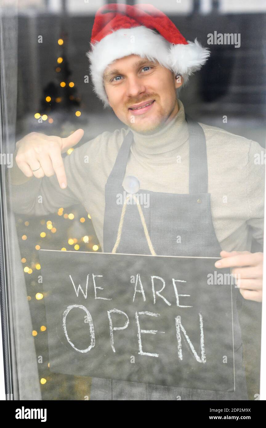 Young man holding open sign in cafe Stock Photo - Alamy