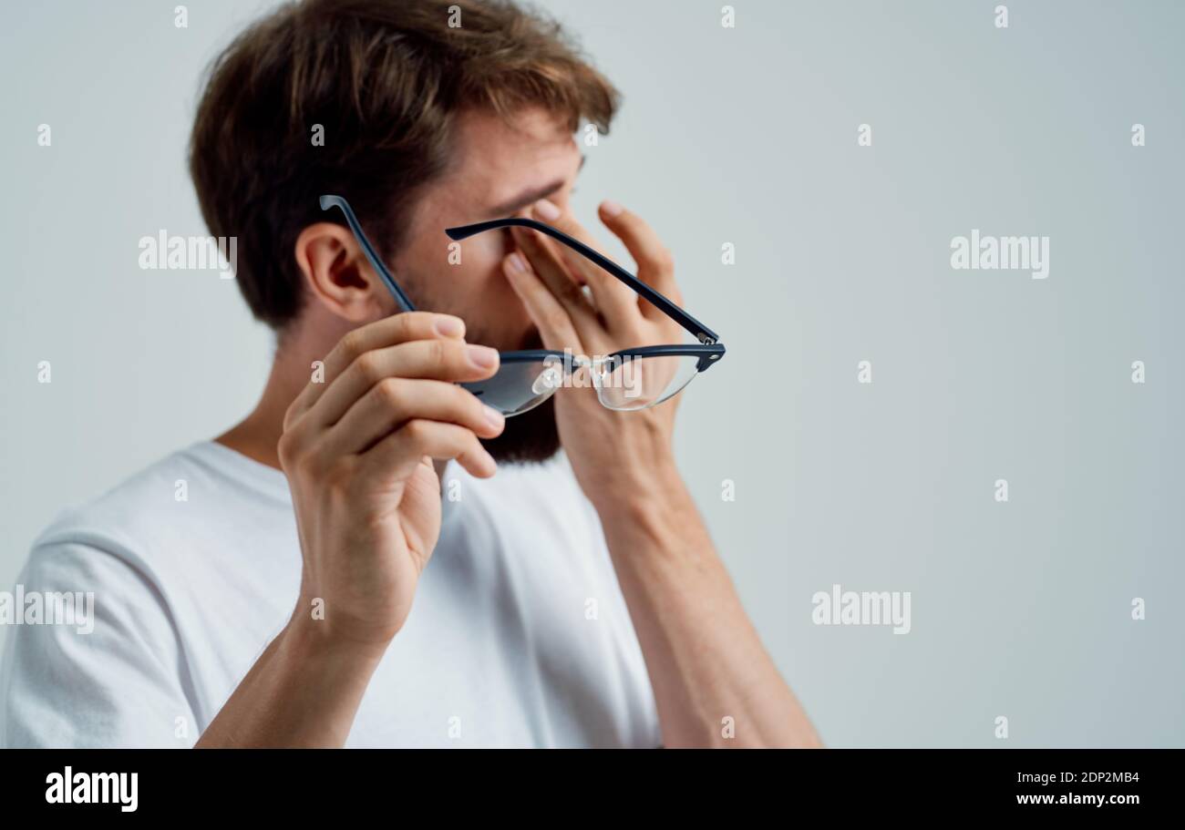 vision problems man holding glasses in hand pain in the eyes gray ...