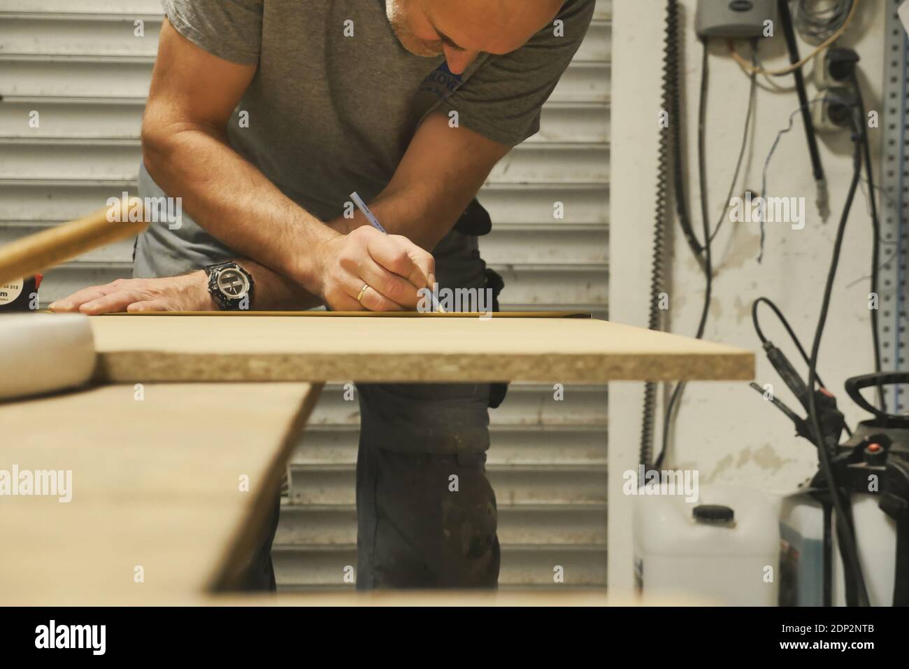 Carpenter drawing line with pencil on wooden surface. Medium shot Stock ...