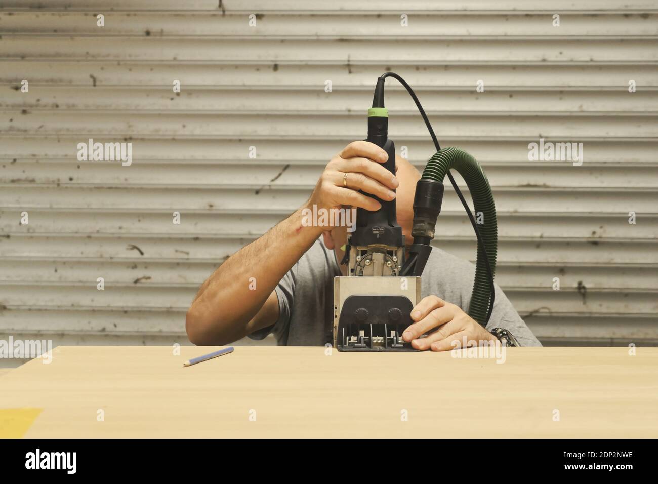 Carpenter using wood framing tool. Front view. Medium shot Stock Photo ...