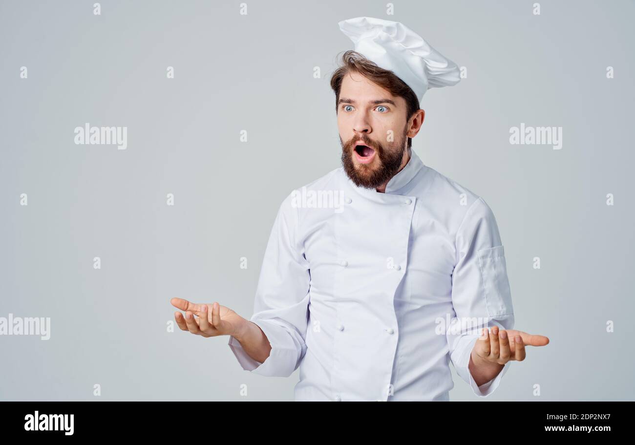 The professional chef gestures with his hands on a light background ...