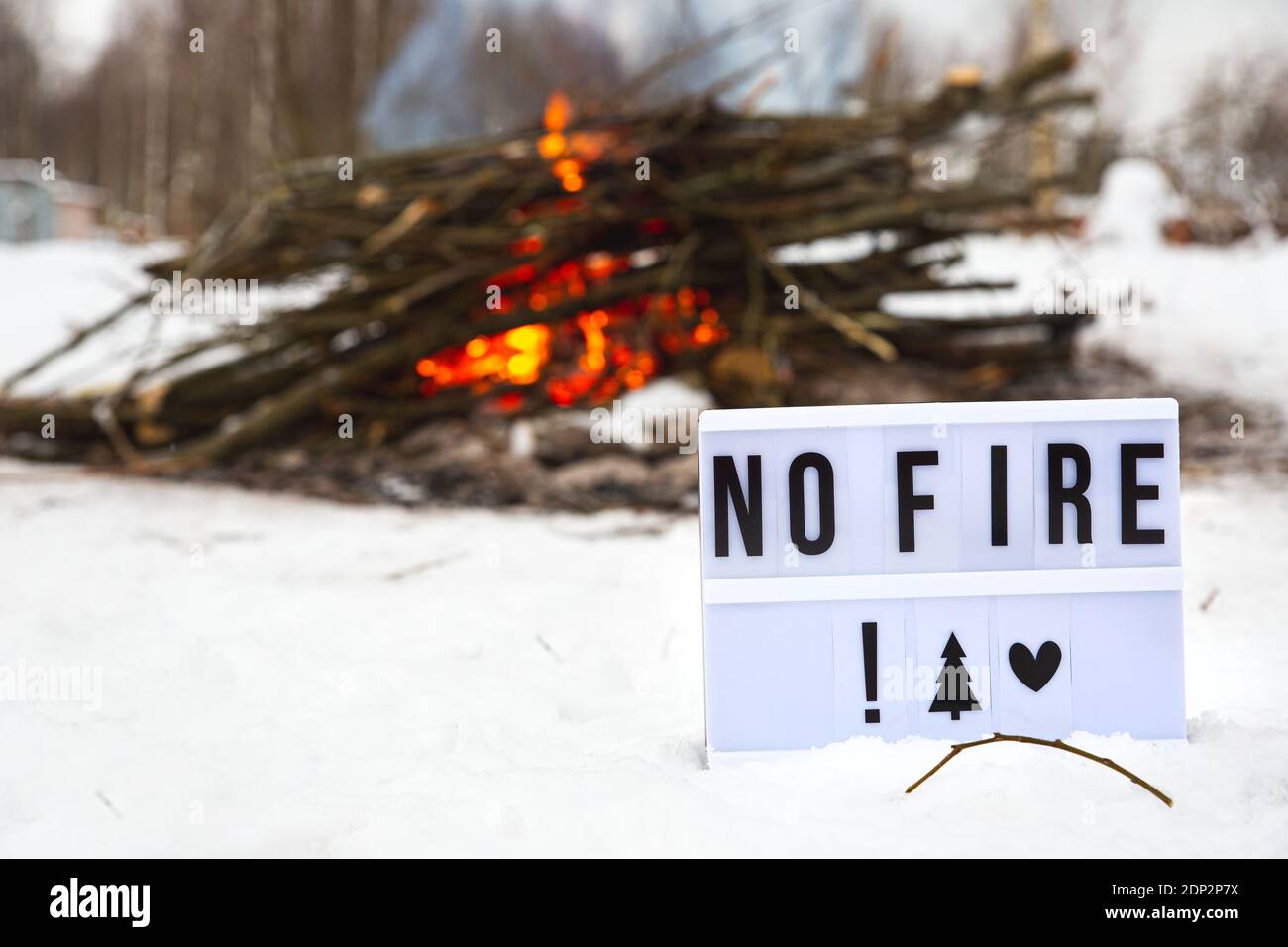 A sign with the text No fire against the background of a large blazing ...
