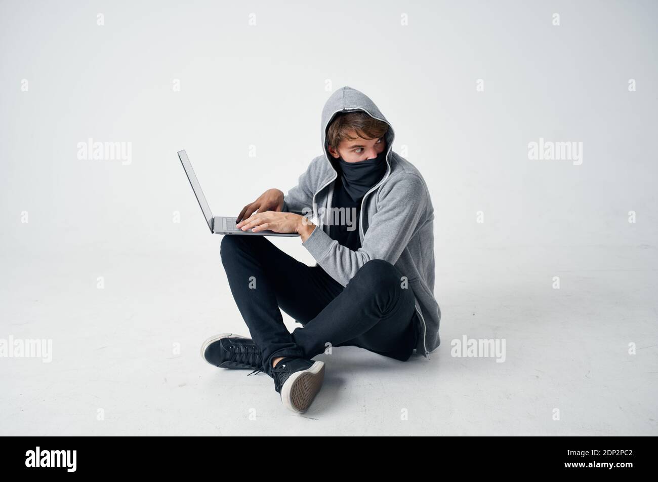 man in gray hoodie with laptop hidden mask hacking computer Stock Photo ...