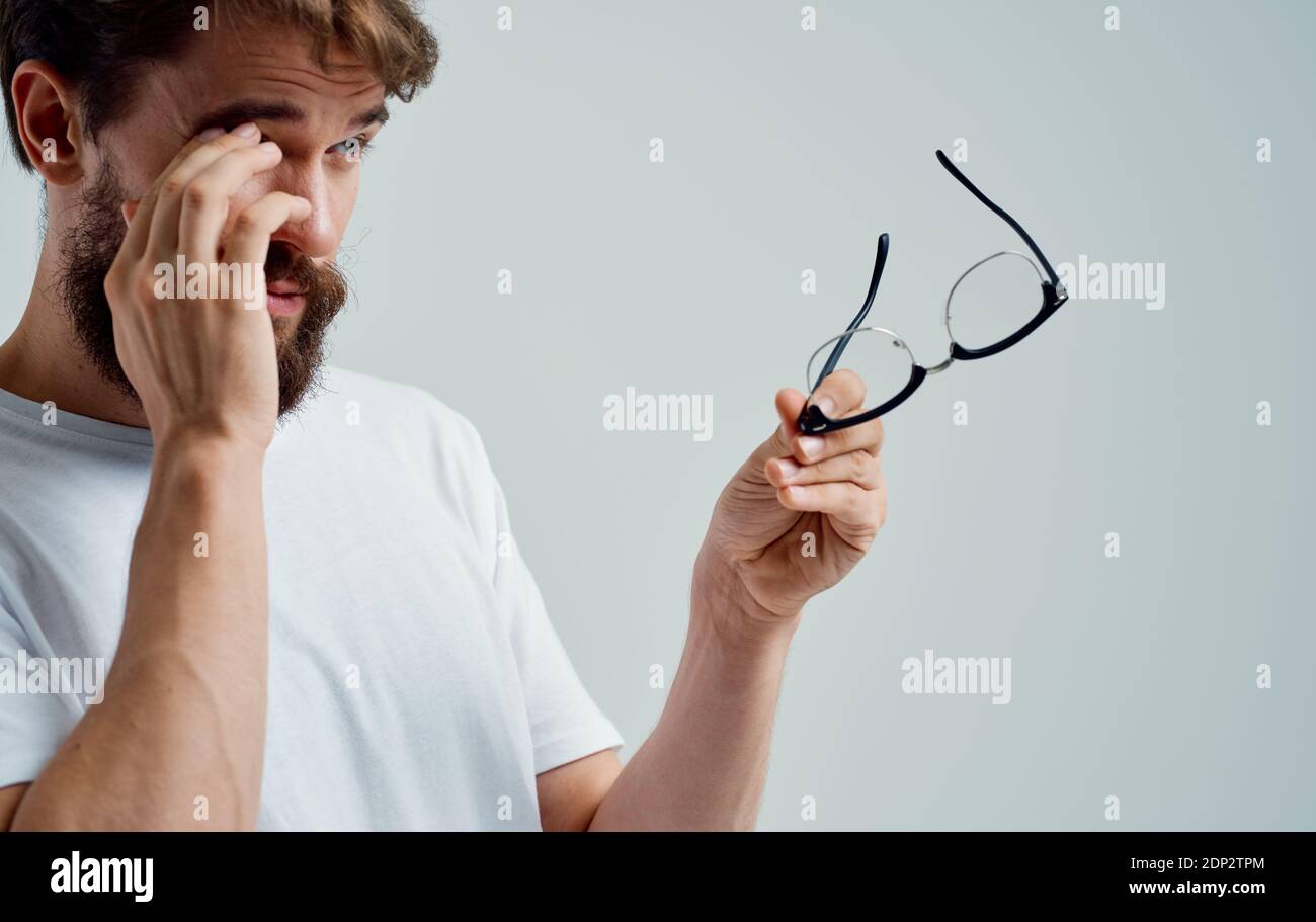 vision problems man holding glasses in hand pain in the eyes gray ...
