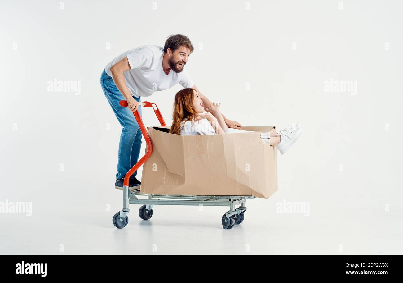 cheerful man and woman in a box on a cargo trolley emotions light ...
