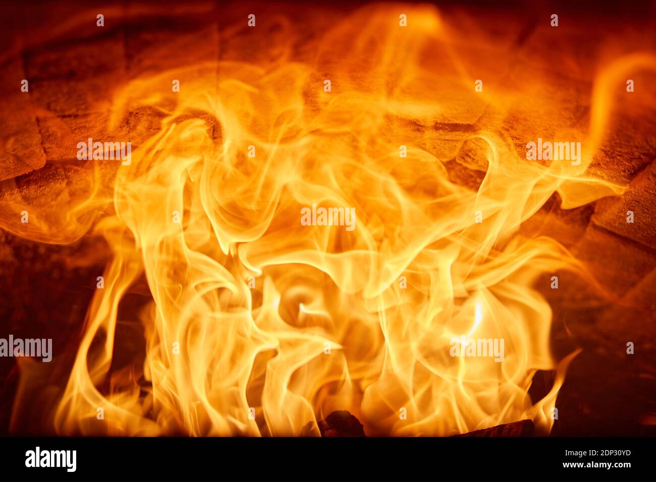 Burning fire flames on a dark background in a wood stove in defocus ...