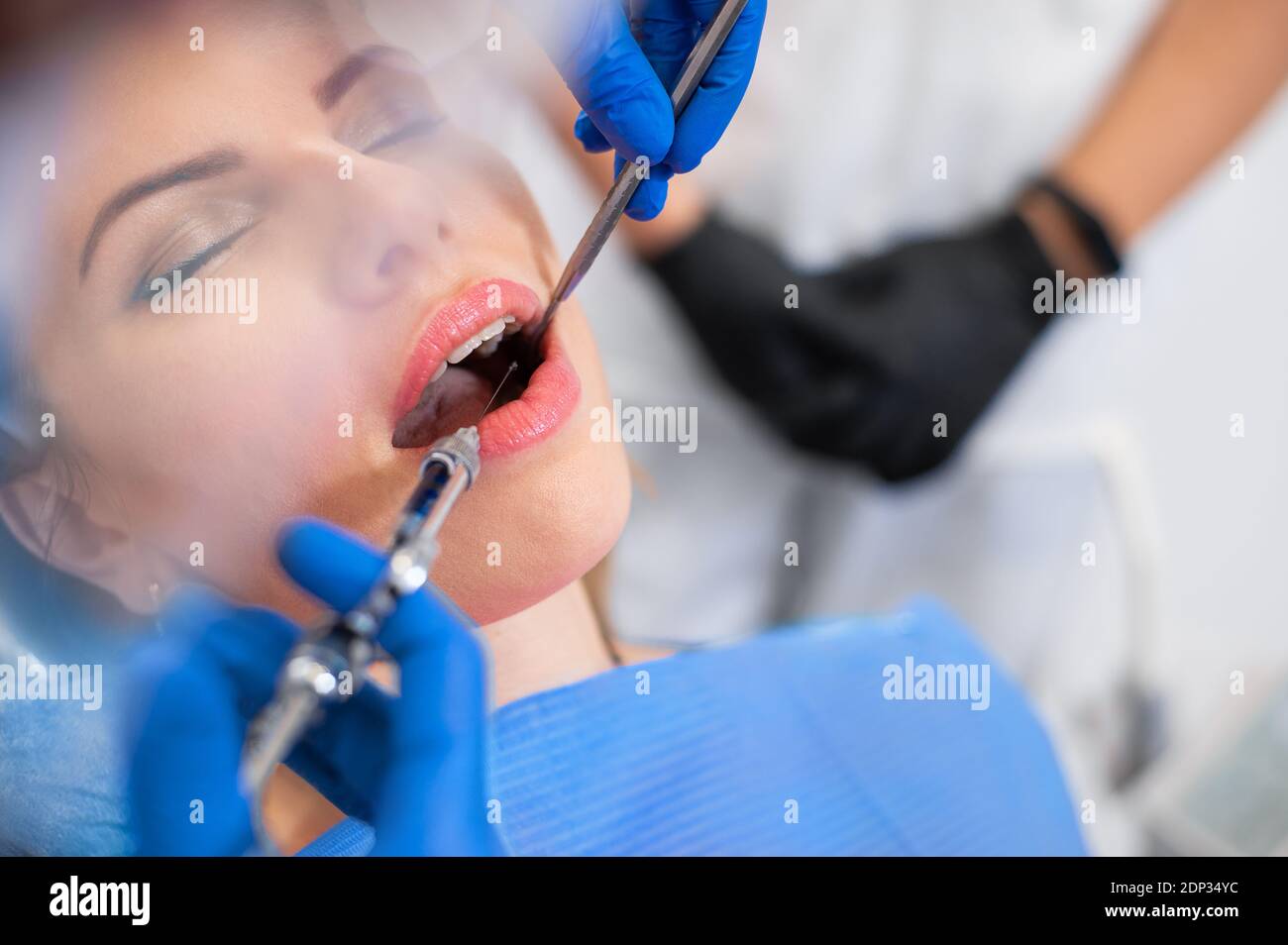 The doctor makes an injection with an anesthetic to the patient during ...