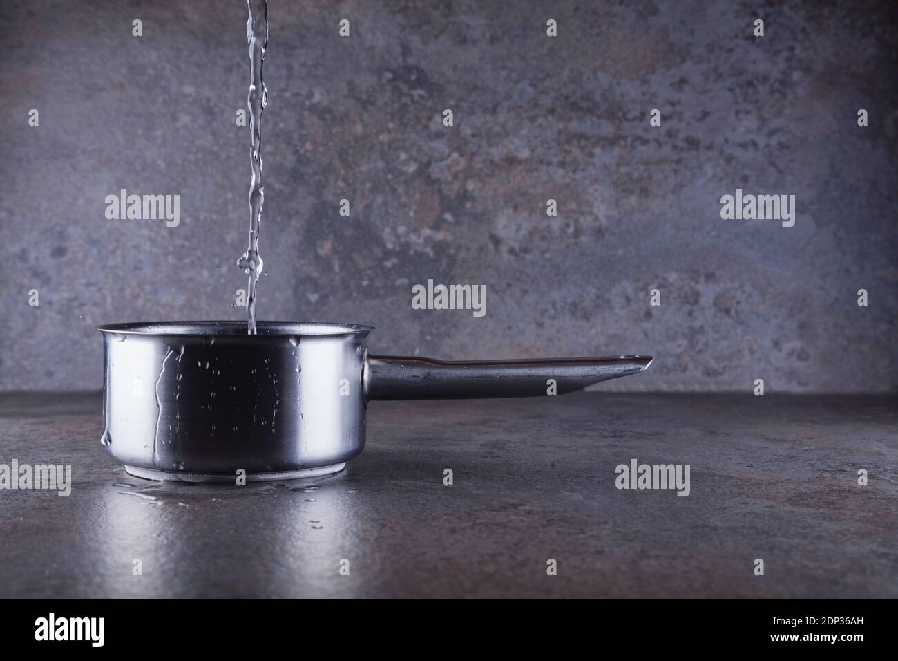Water pouring into a stainless steel saucepan Stock Photo - Alamy