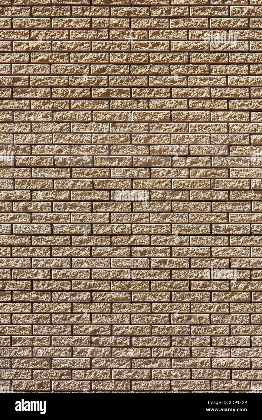 brick facade wall made of stone, beige texture of the building vertical ...