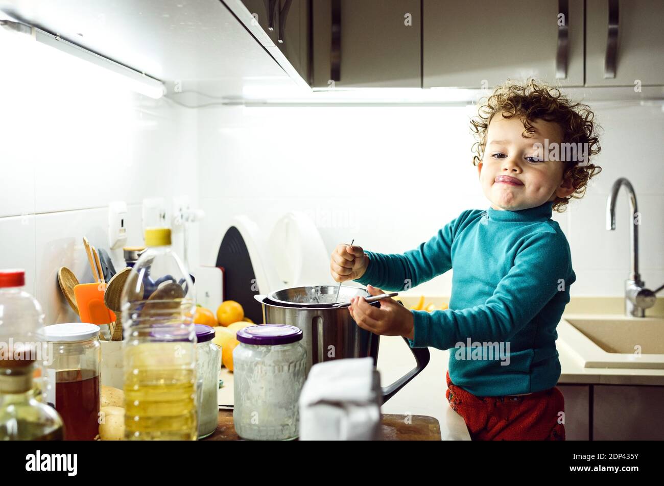 Adorable little girl helps to cook and makes funny and curious ...