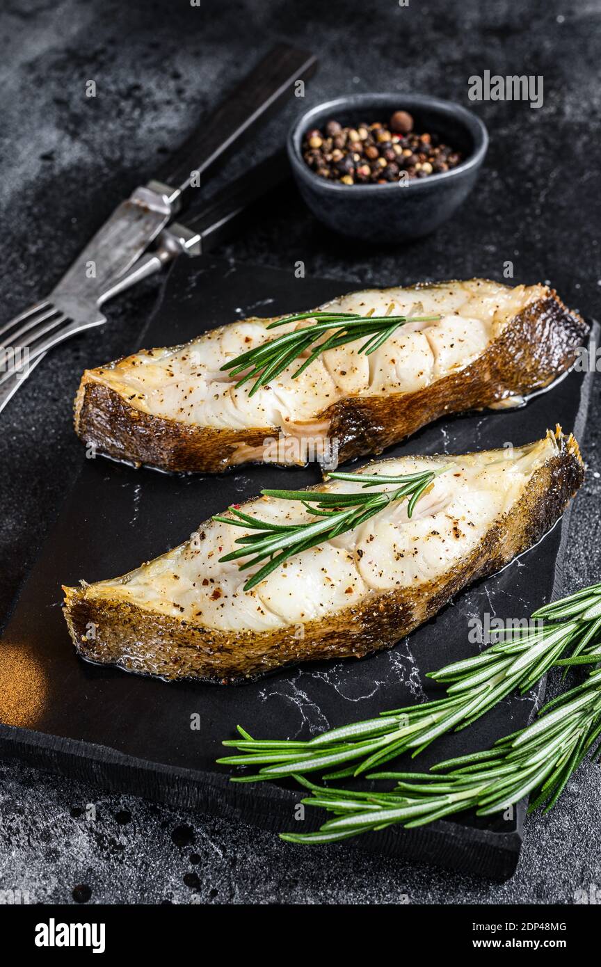Baked halibut fish steak. Black background. Top view Stock Photo - Alamy