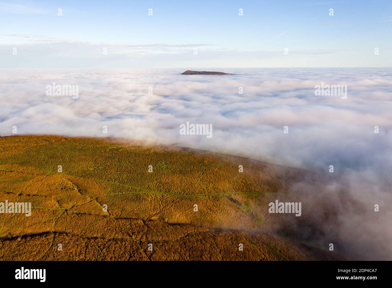 Aerial view of mountains rising through a sea of clouds (Skirrid Fawr ...