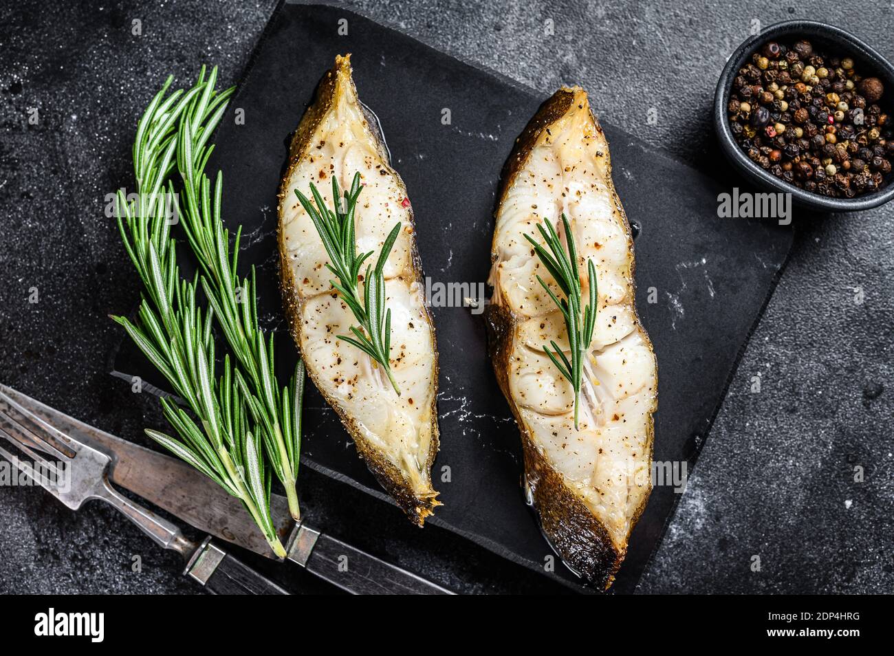 Halibut fish steak with rosemary. Black background. Top view Stock ...