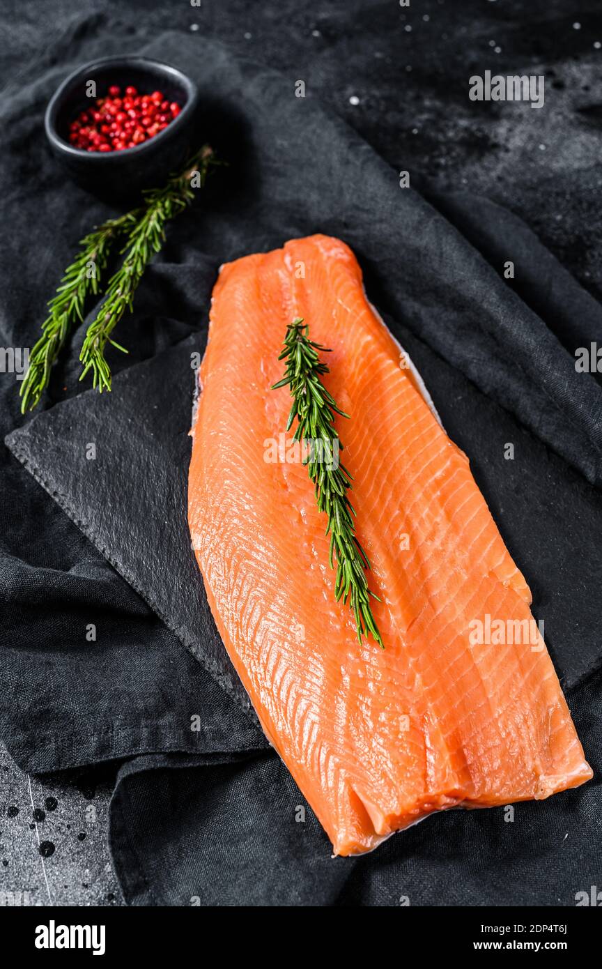 Raw trout fillet with rosemary and pink pepper. Organic fish. Black ...