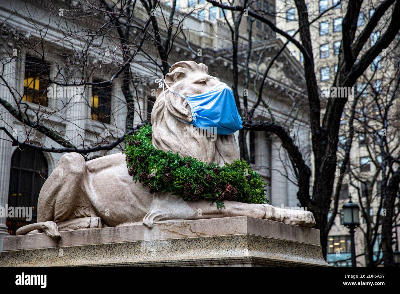 The statue of Fortitude the lion wears a mask and Christmas wreath ...