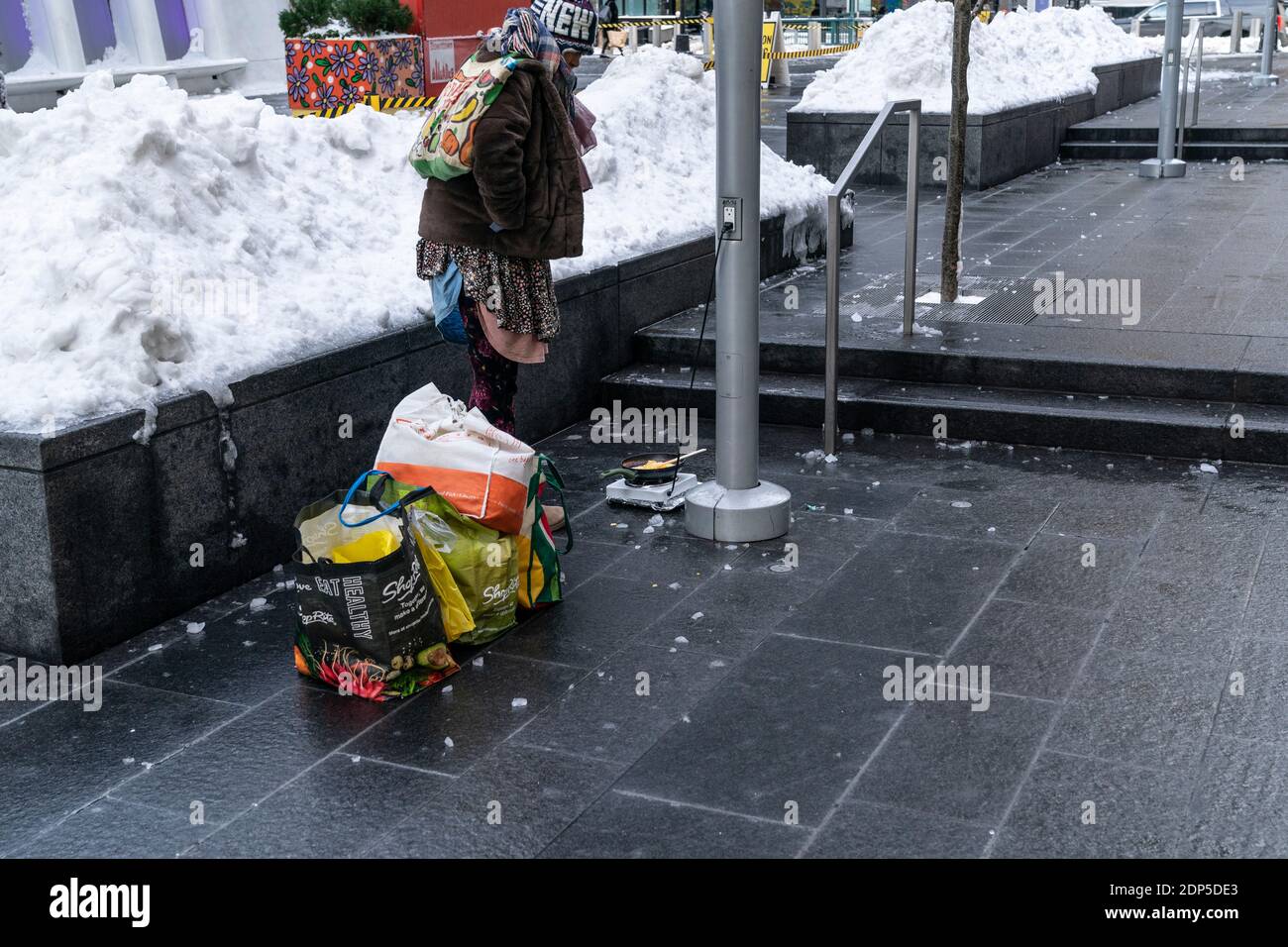 New York, NY - December 18, 2020: Homeless woman cooks scramble eggs on ...