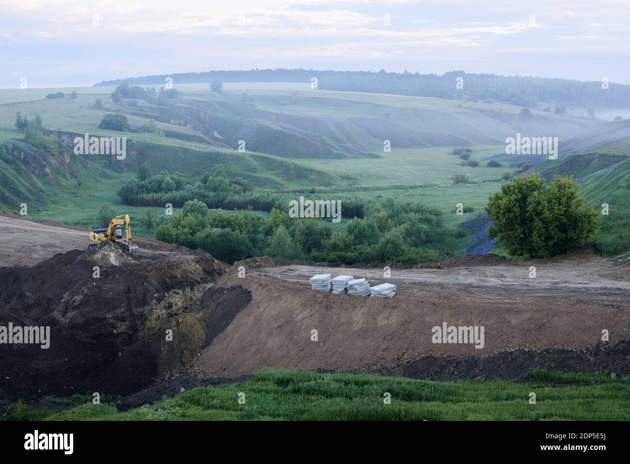 Country landscape with hills and ravines in misty summer morning ...
