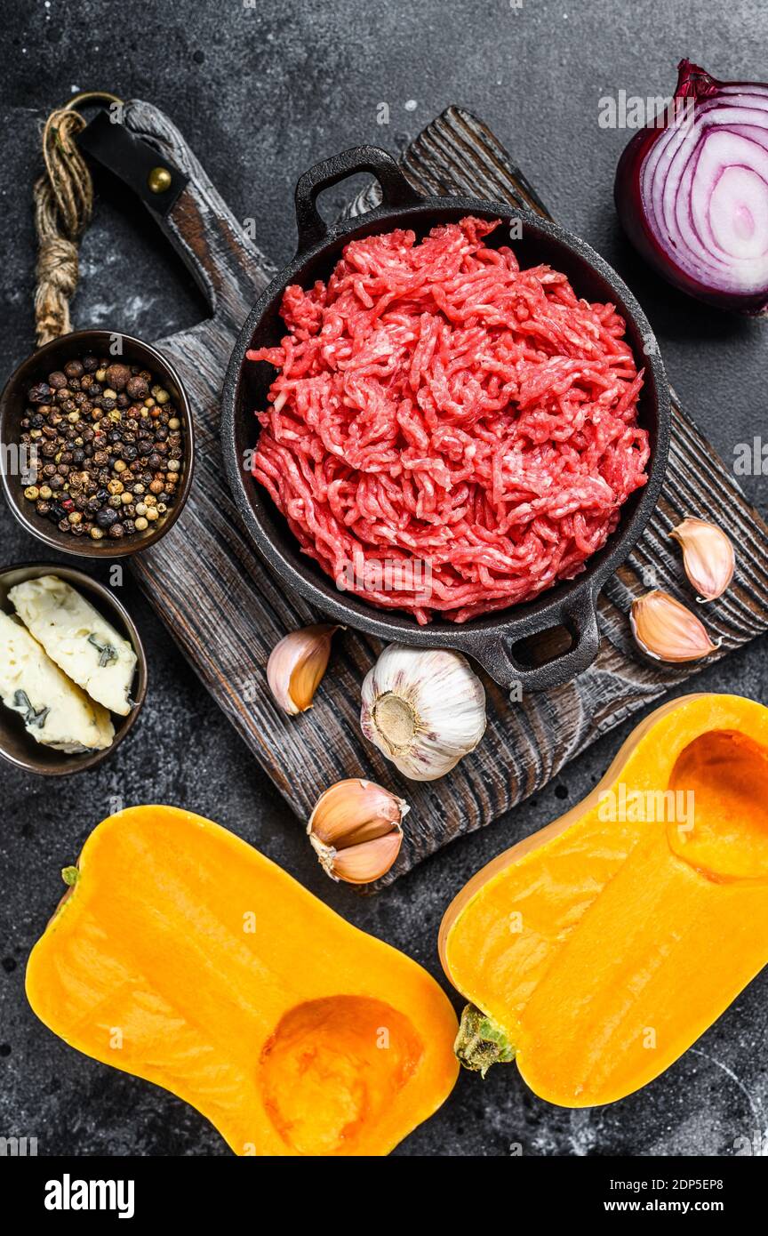 Raw mince meat, pumpkin with garlic and onion. Black background. Top ...