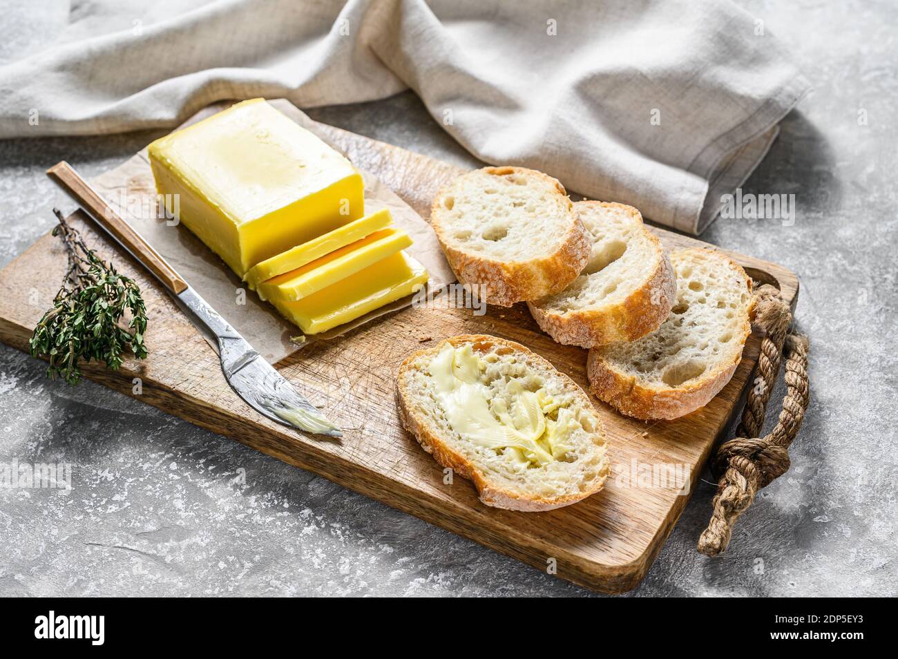 Farm butter and fresh baguette with butter. Gray background.Top view ...