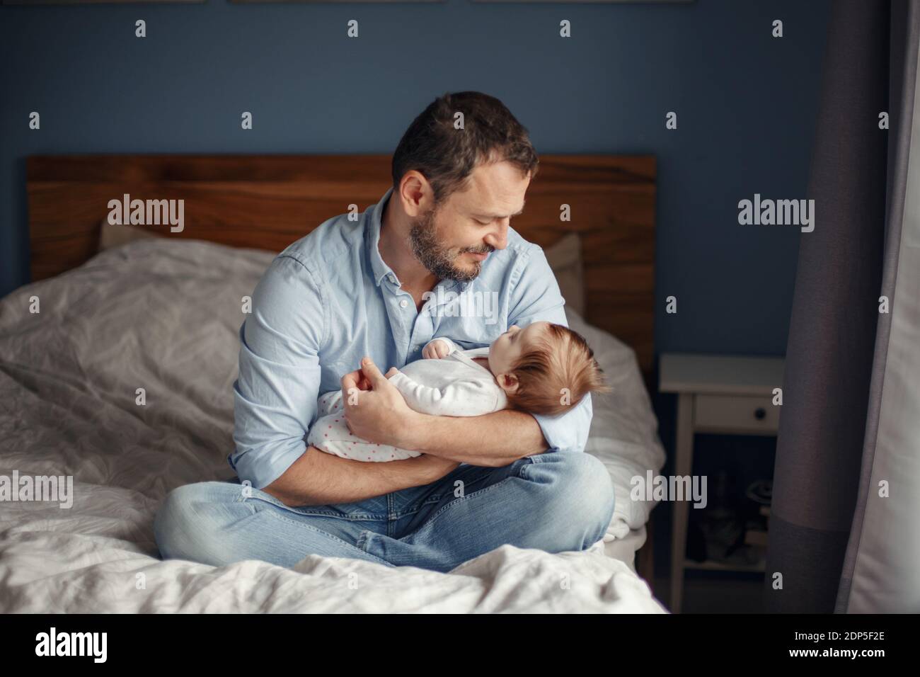 Fathers Day. Middle age Caucasian father with sleeping newborn baby ...