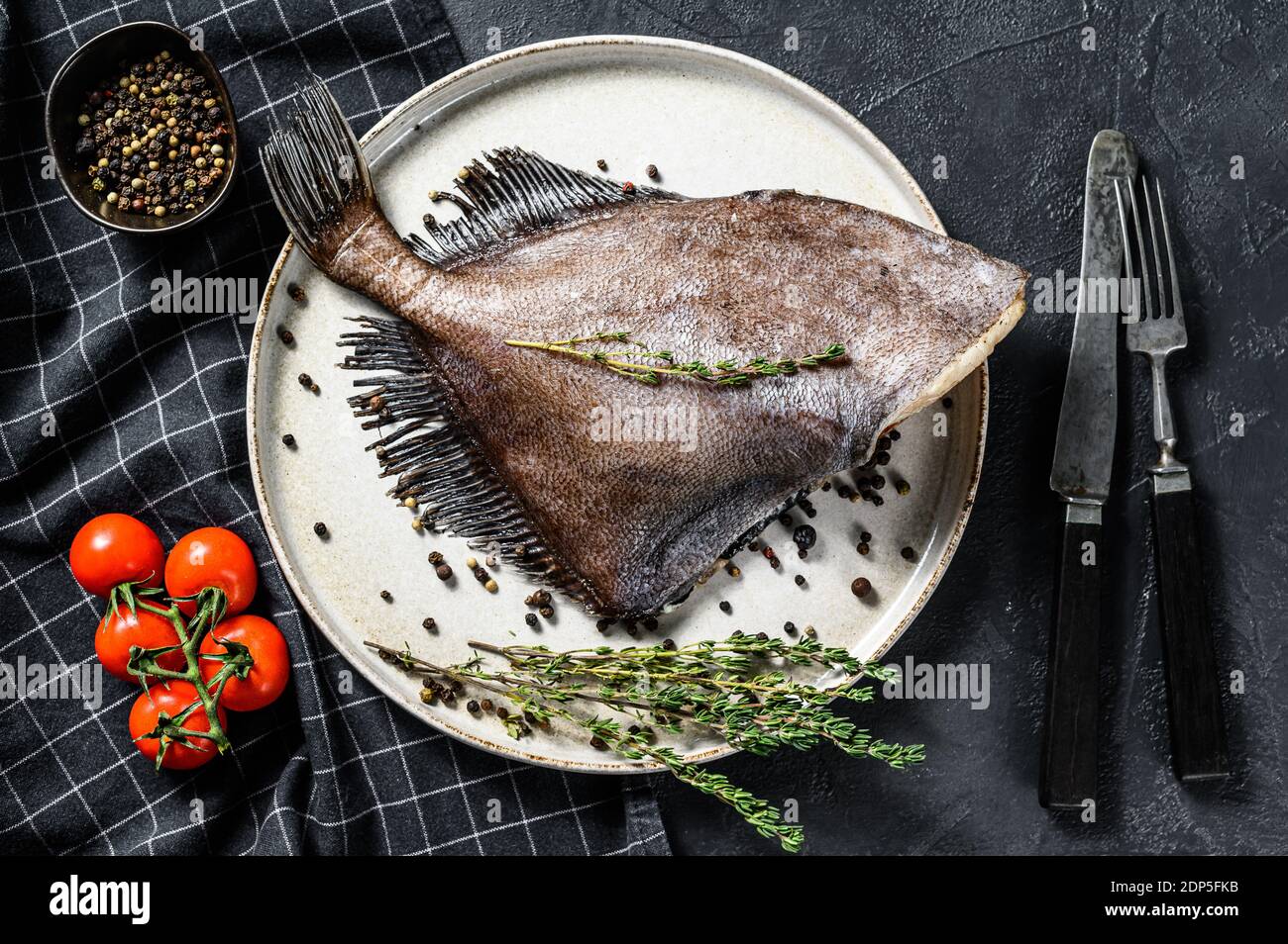 John Dory fish with pink pepper and thyme. Black background. Top view ...